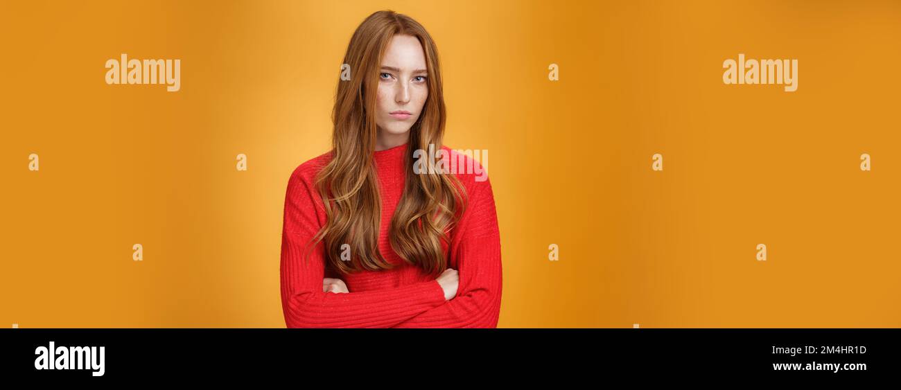 Suspicious intense and defensive ginger girl standing in passive ...