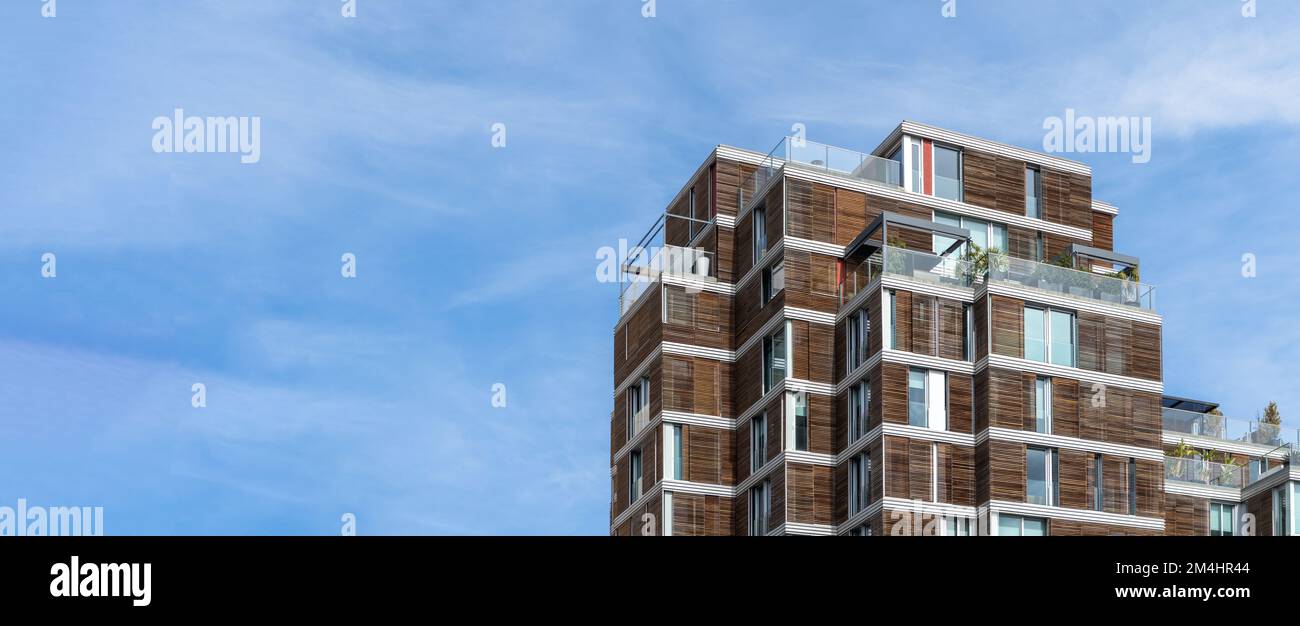 View of a modern building with wooden cladding facade over blue sky and ...
