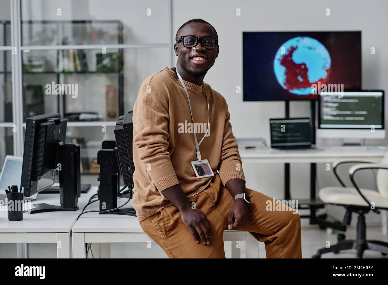 Portrait of young African American developer smiling at camera sitting ...