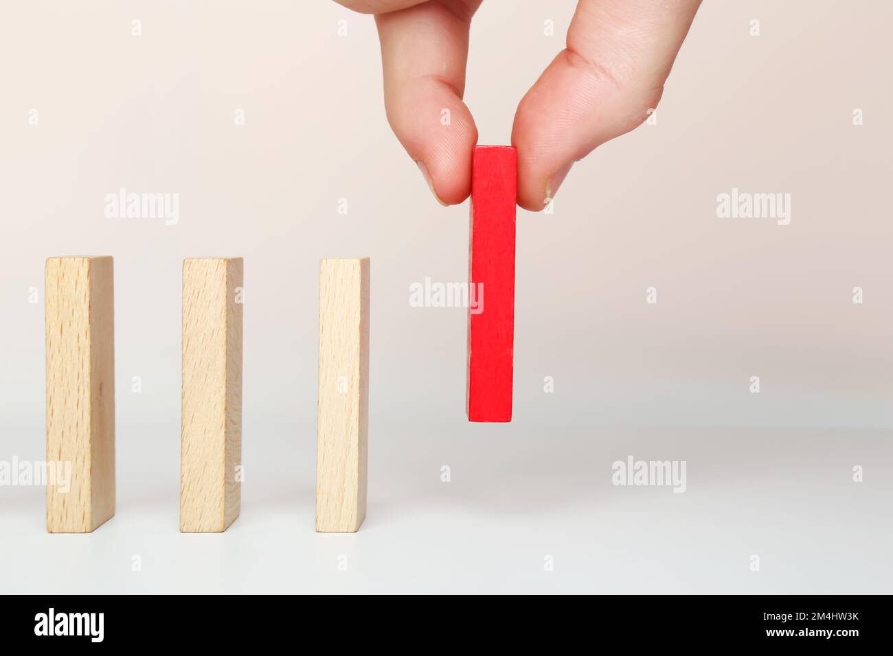 A business concept with a domino effect. The hand puts dominoes to make ...