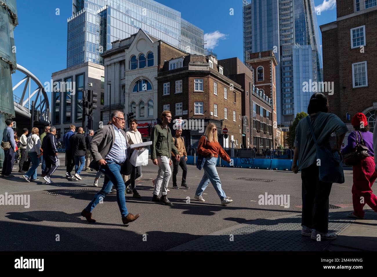 Pedestrians crossing Bedale Street by Borough market. Part of The Shard ...