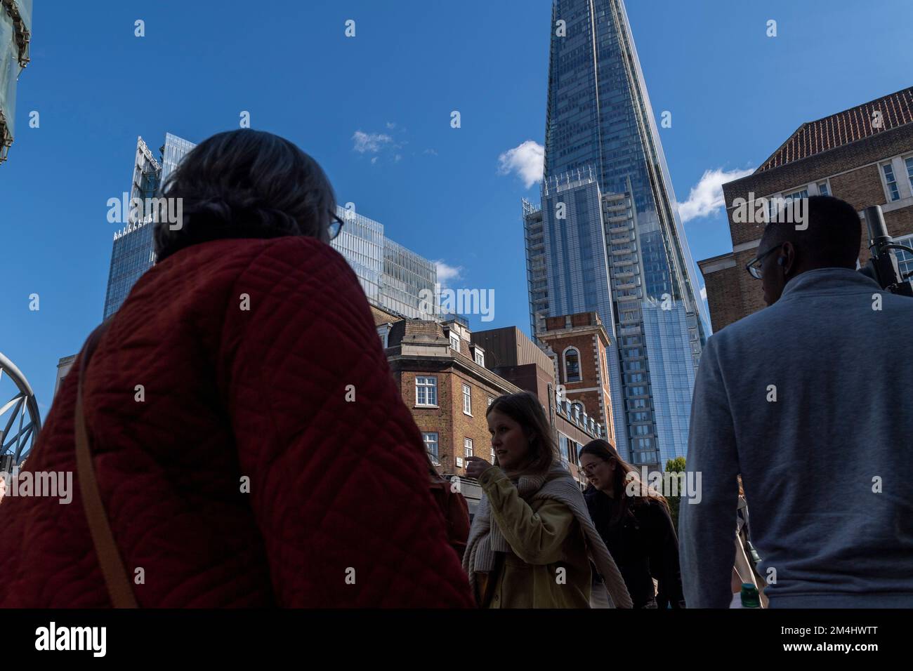 Pedestrians crossing Bedale Street by Borough market. Part of The Shard ...