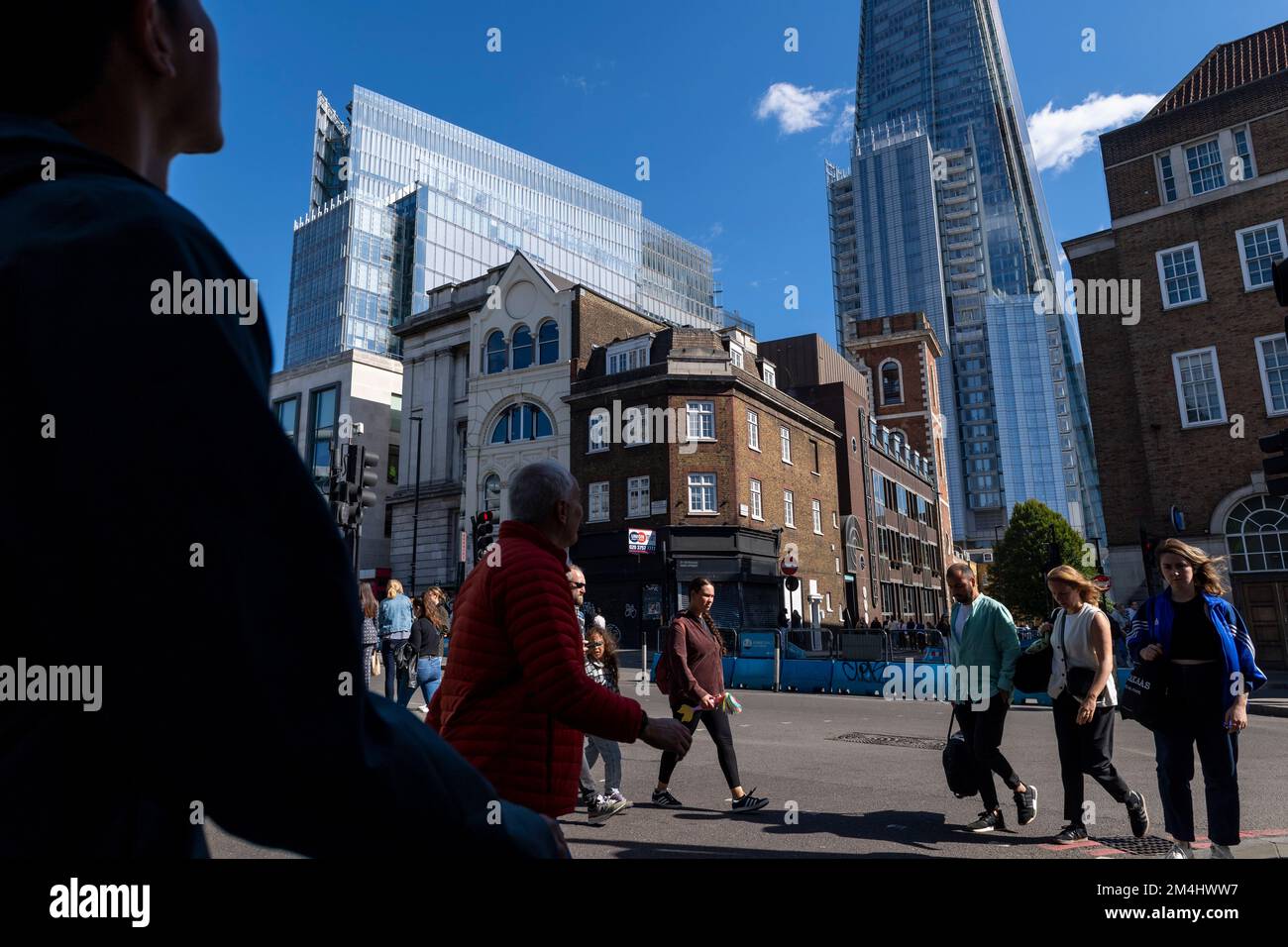 Pedestrians crossing Bedale Street by Borough market. Part of The Shard ...