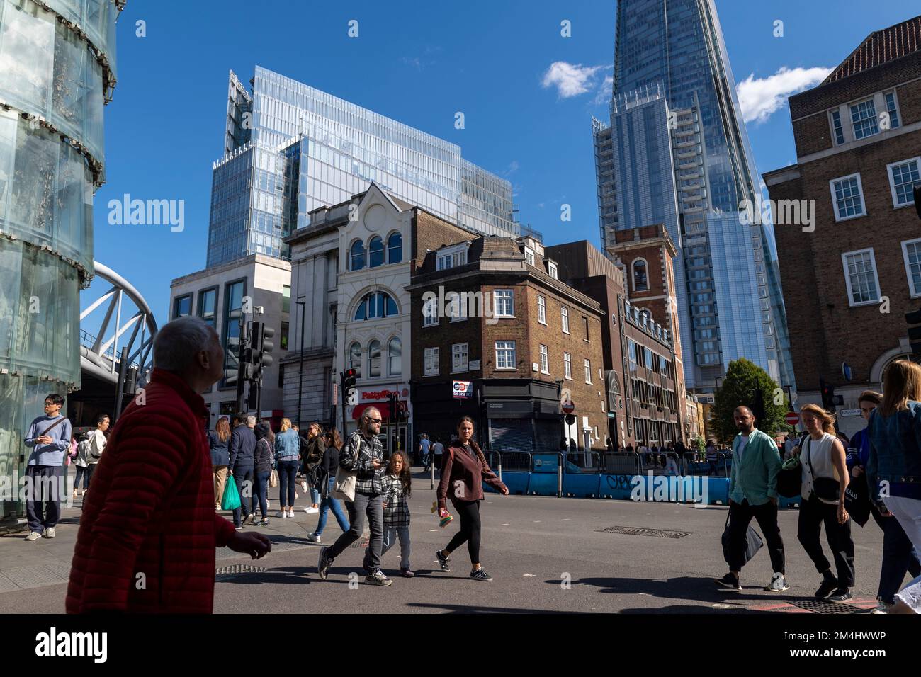Pedestrians crossing Bedale Street by Borough market. Part of The Shard ...