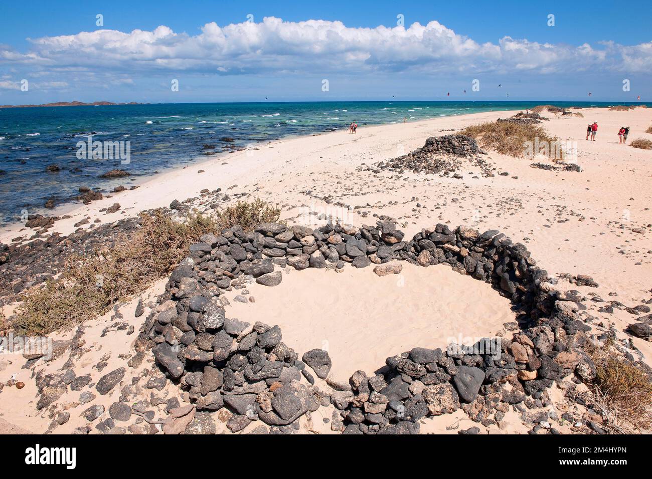 Stone castle built by tourists as a privacy screen windbreak on a sandy ...