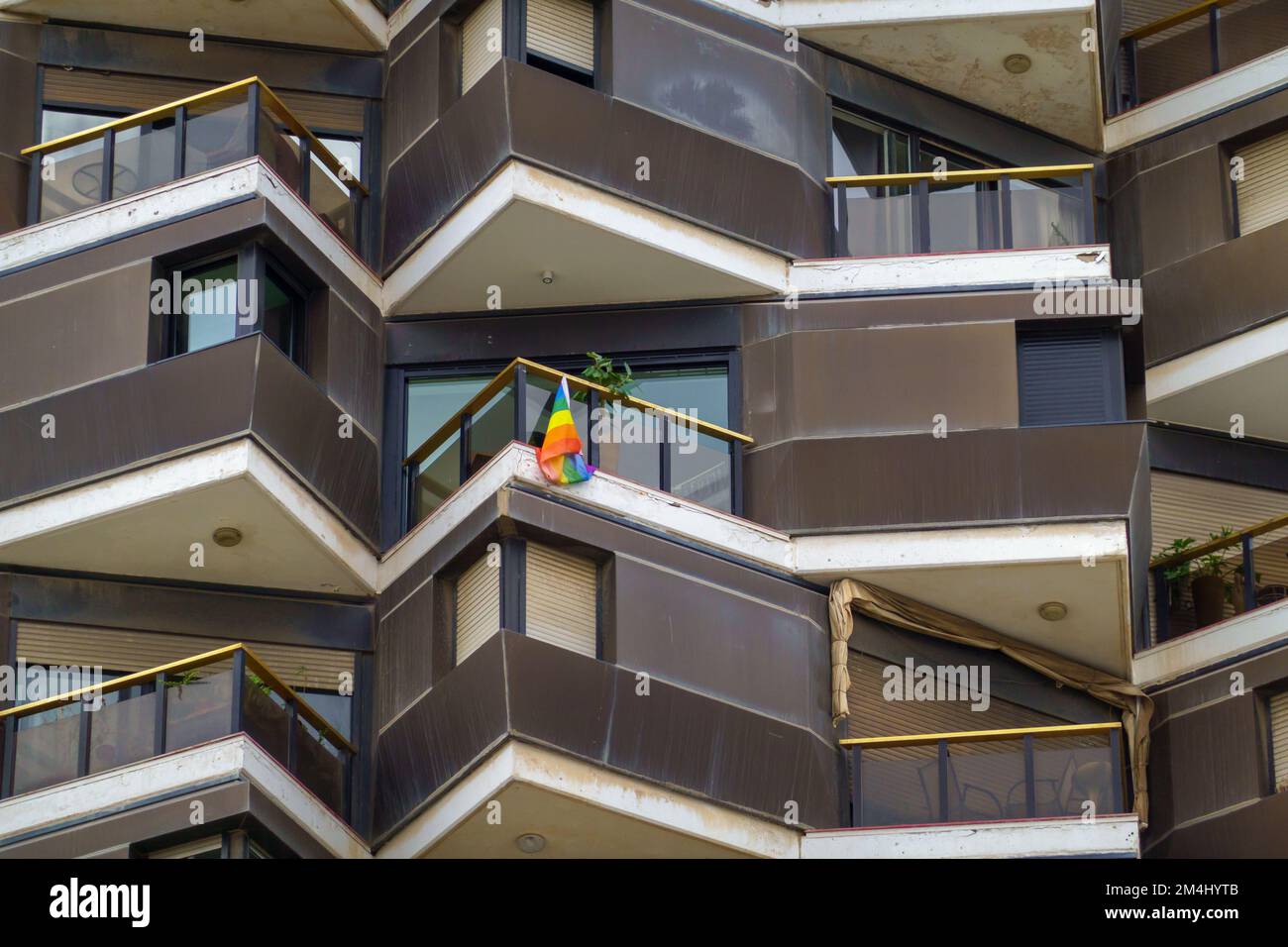 From below rainbow flag hanging on balcony of geometric apartment ...