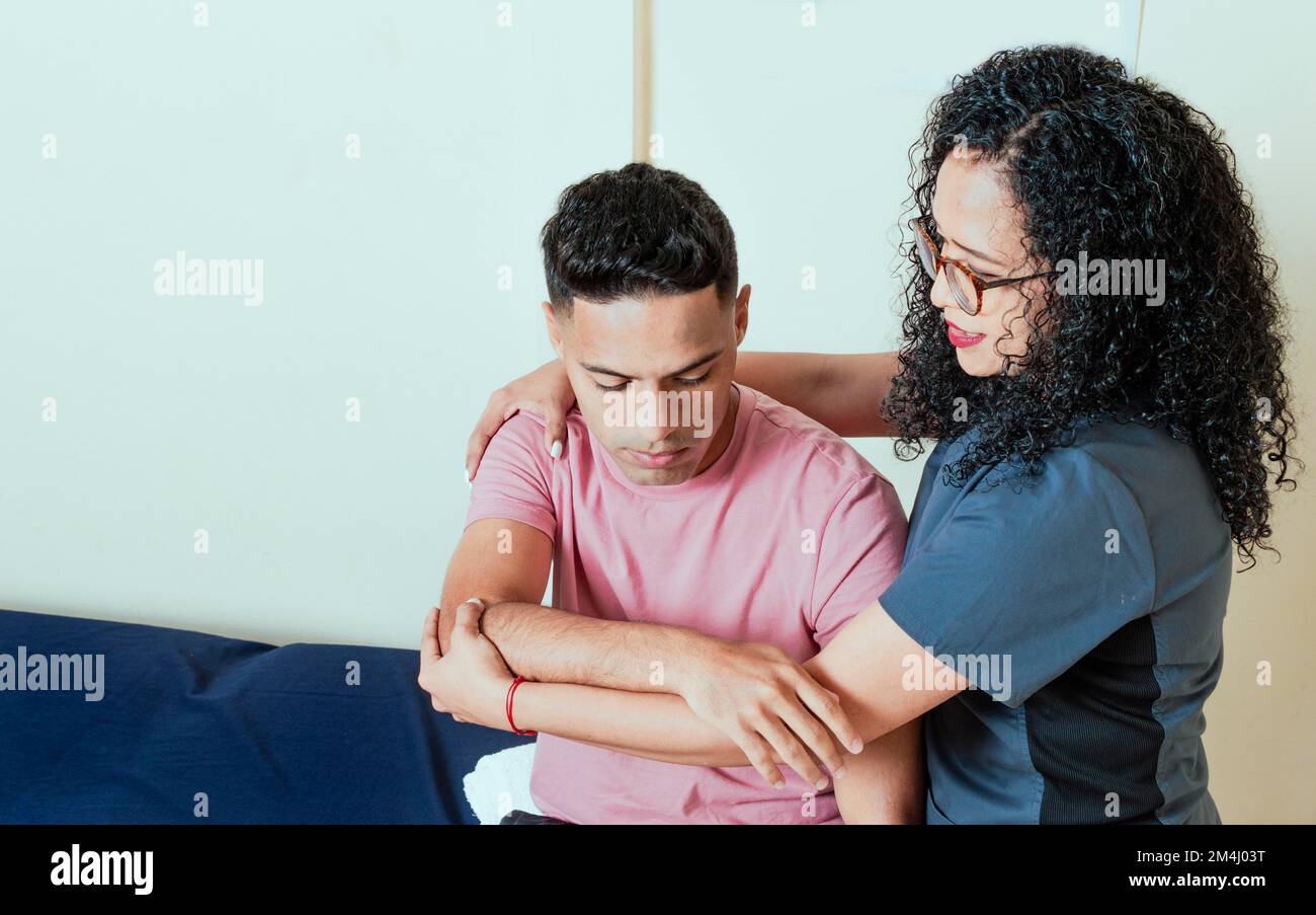 Physiotherapist woman evaluating a patient's arm in the office, female ...