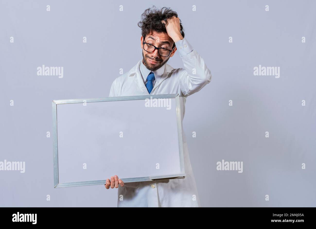 Male scientist in white coat holding and pointing at a blank whiteboard ...