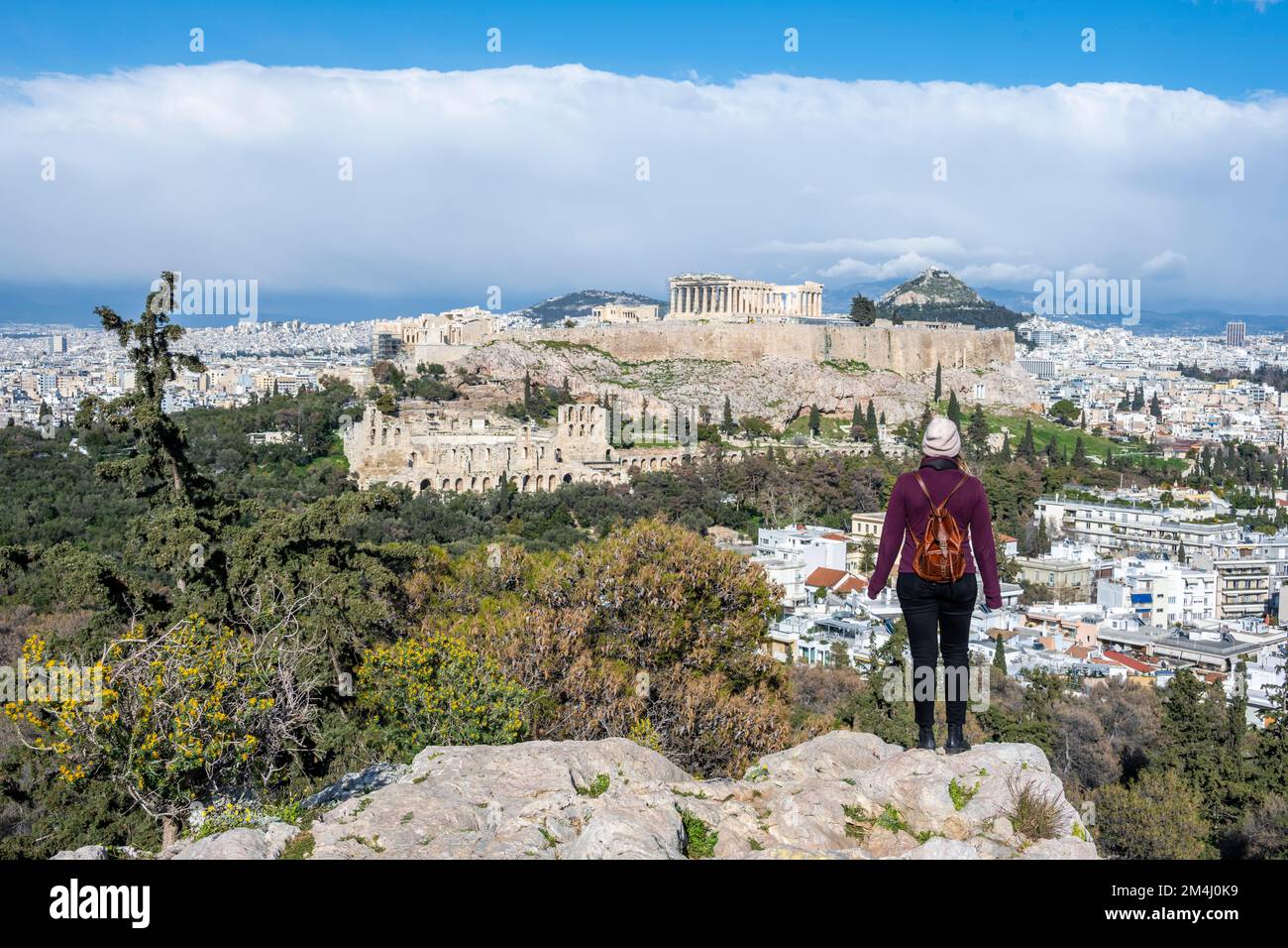 Tourist standing on rock, view from Philopappos Hill over the city, panorama of the Parthenon ...