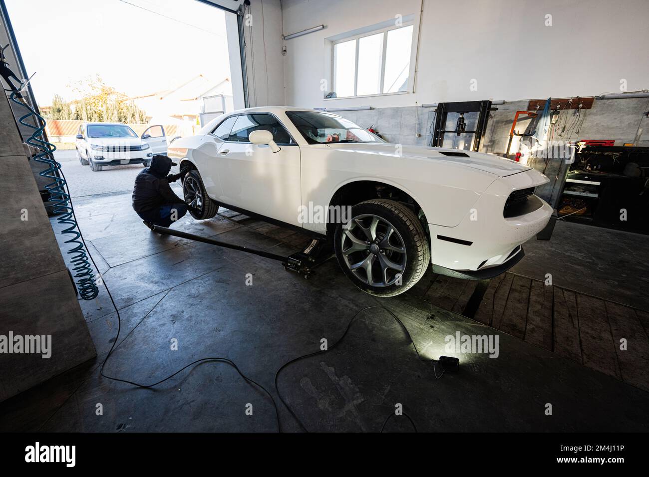 Mechanic in service repair station working with muscle car. Man worker ...