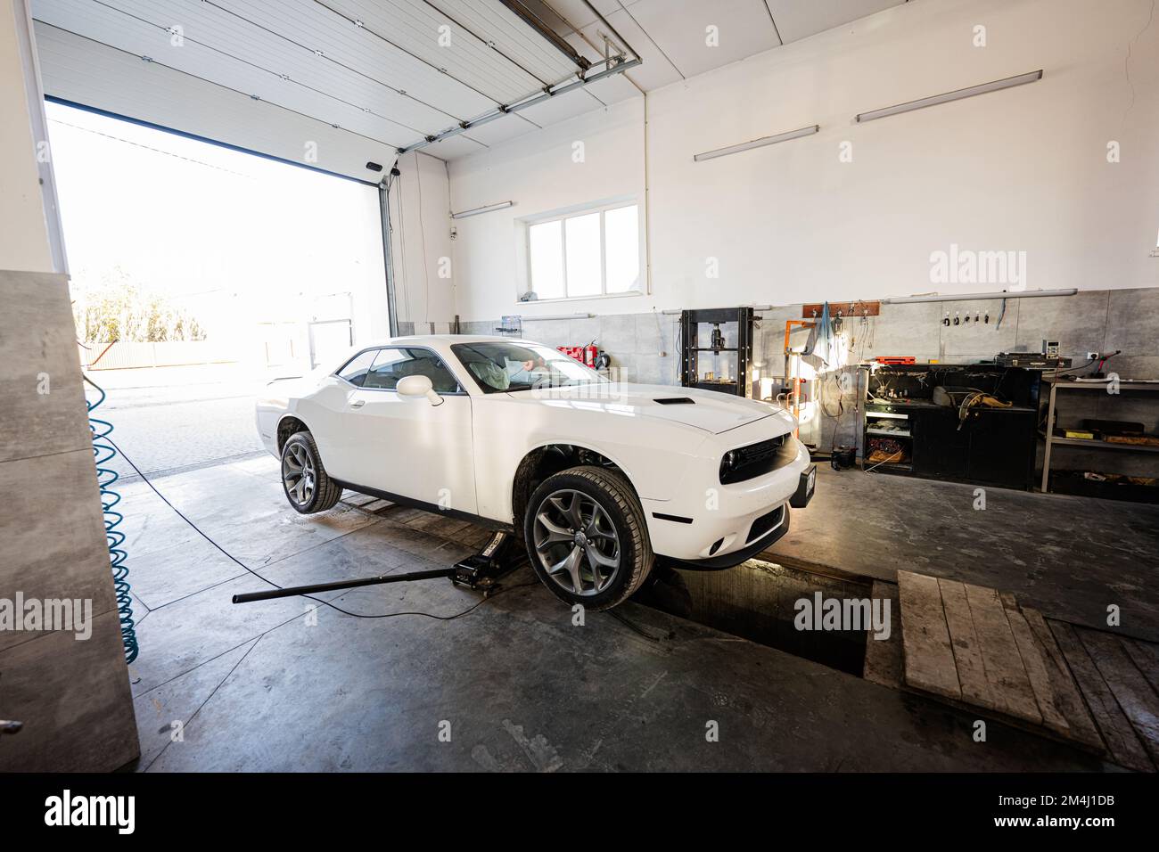Muscle car at service repair station. Jacks up the car to diagnose the ...