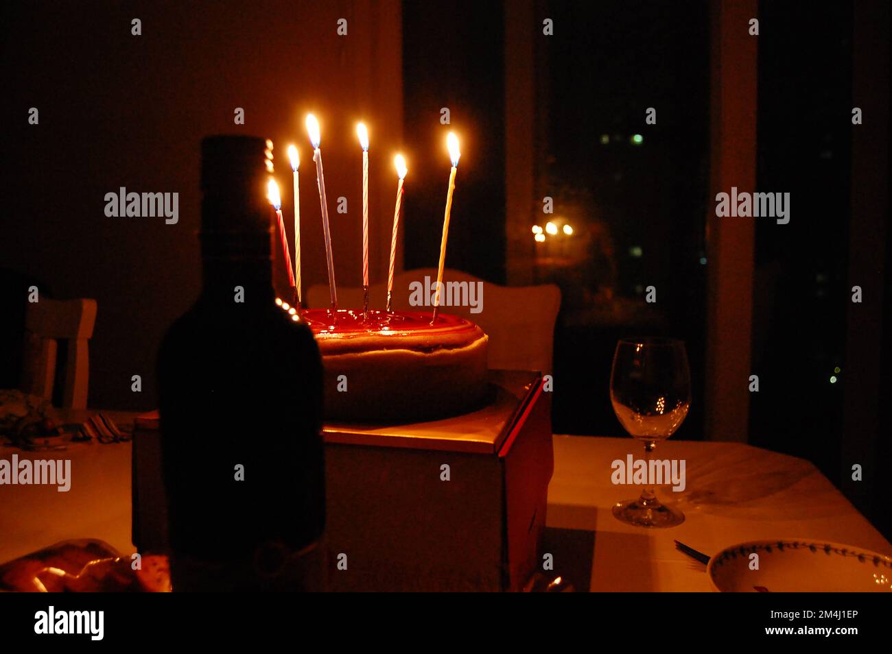Romantic birthday table with 6 candles, cheese cake, wine, glass and ...