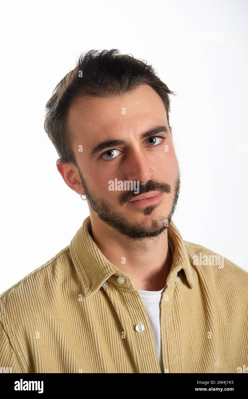 Closeup of a portrait of a young Caucasian man with serious expression ...