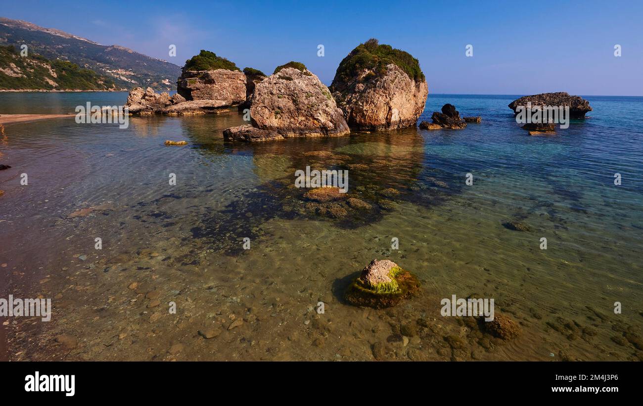 Banana Beach, offshore small rocks in the sea, green vegetation, sea ...