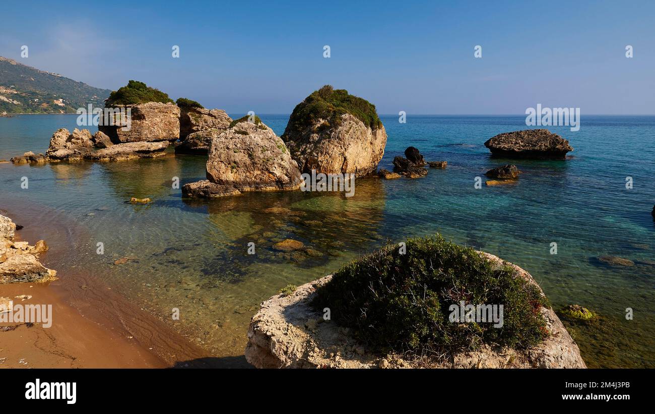 Banana Beach, offshore small rocks in the sea, green vegetation, sea ...
