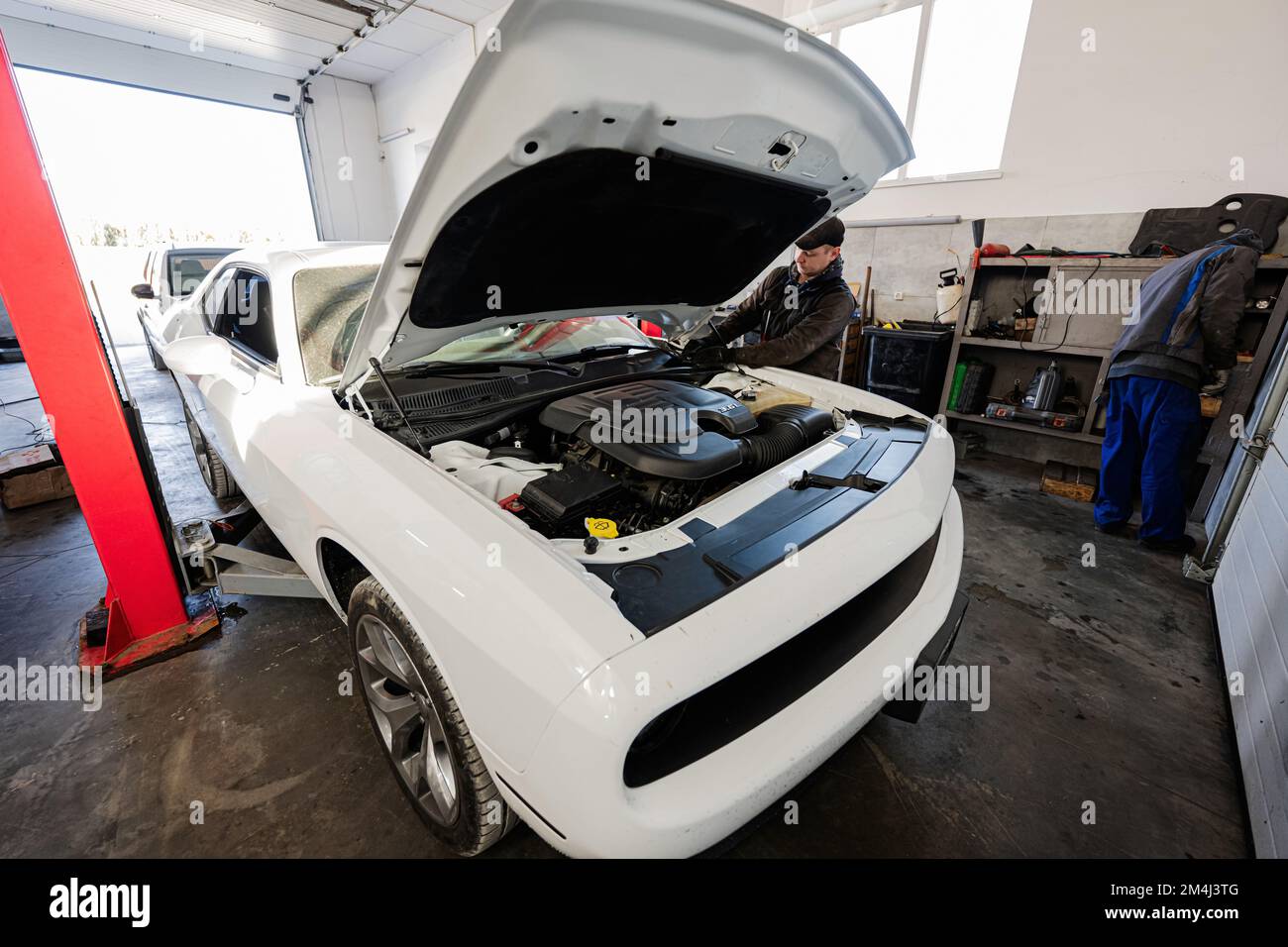 Mechanic in service repair station working with muscle car. Man worker ...