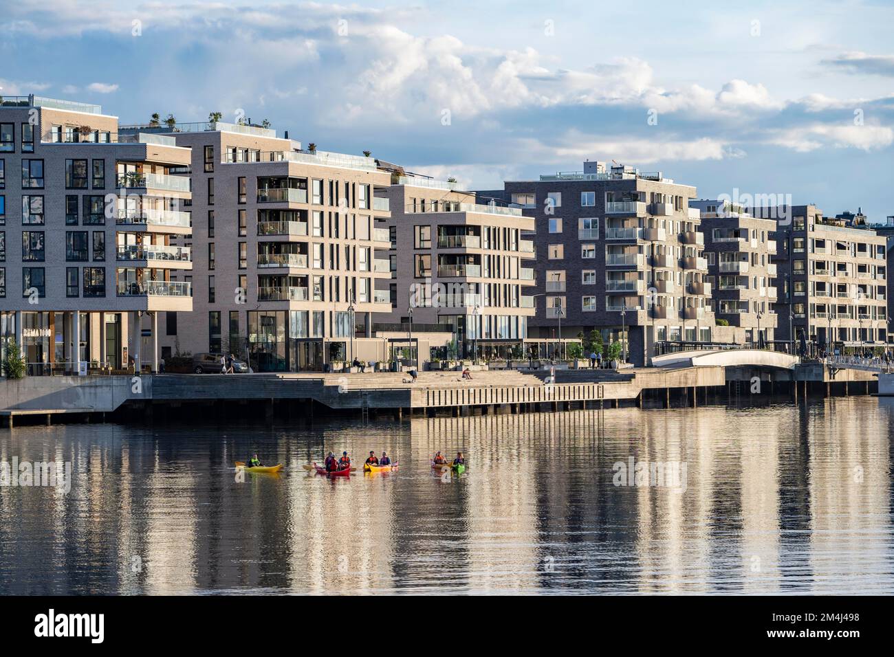 Residential buildings with promenade on the Oslofjord, kayakers ...