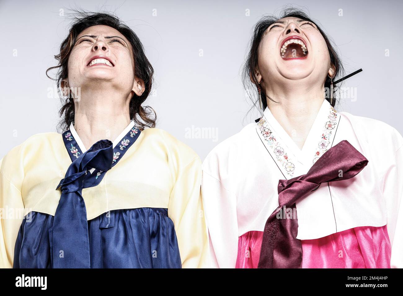 Portrait of two woman in Korean traditional costume with open mouths ...