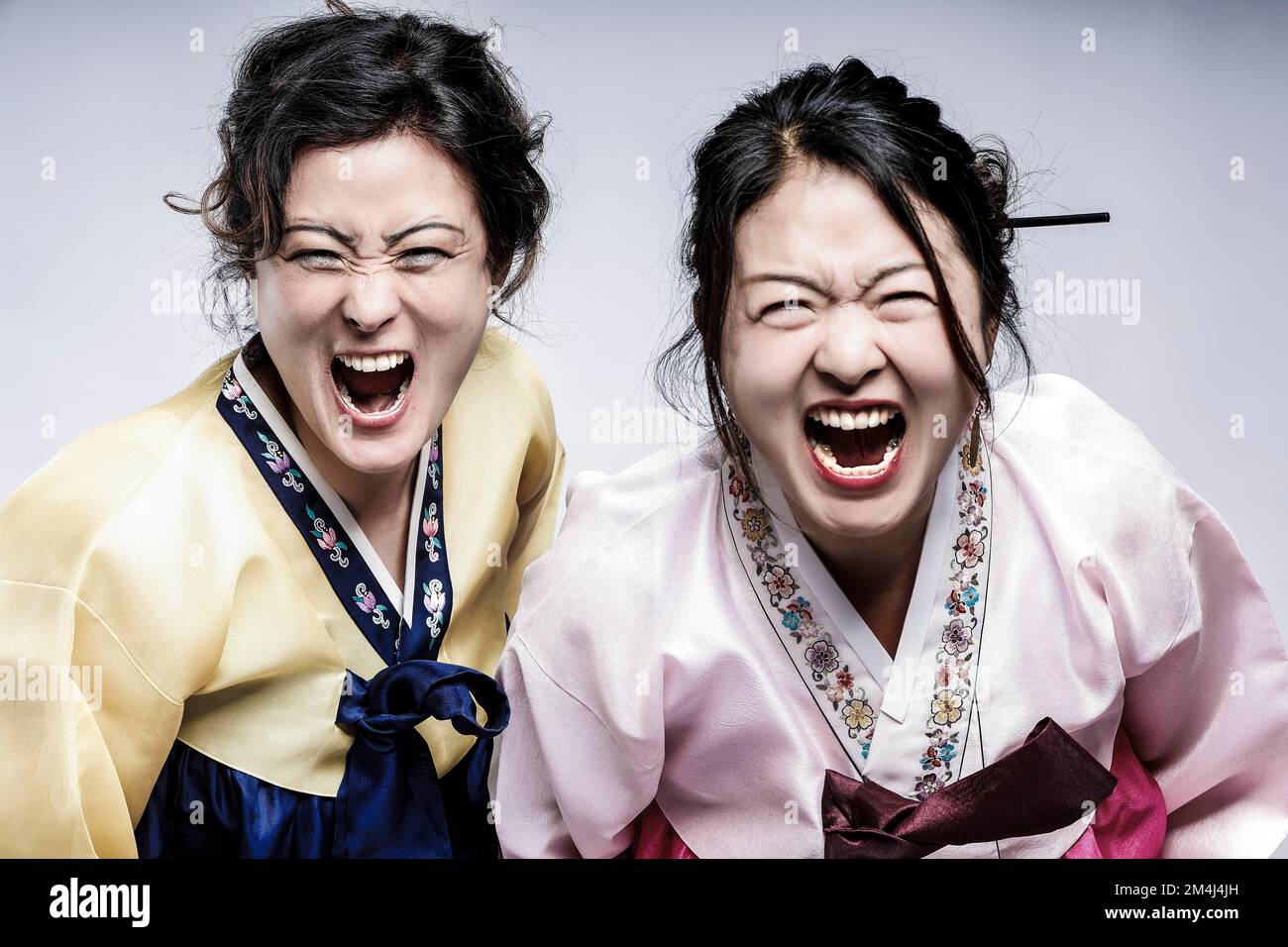 Portrait of two woman in Korean traditional costume with open mouths ...