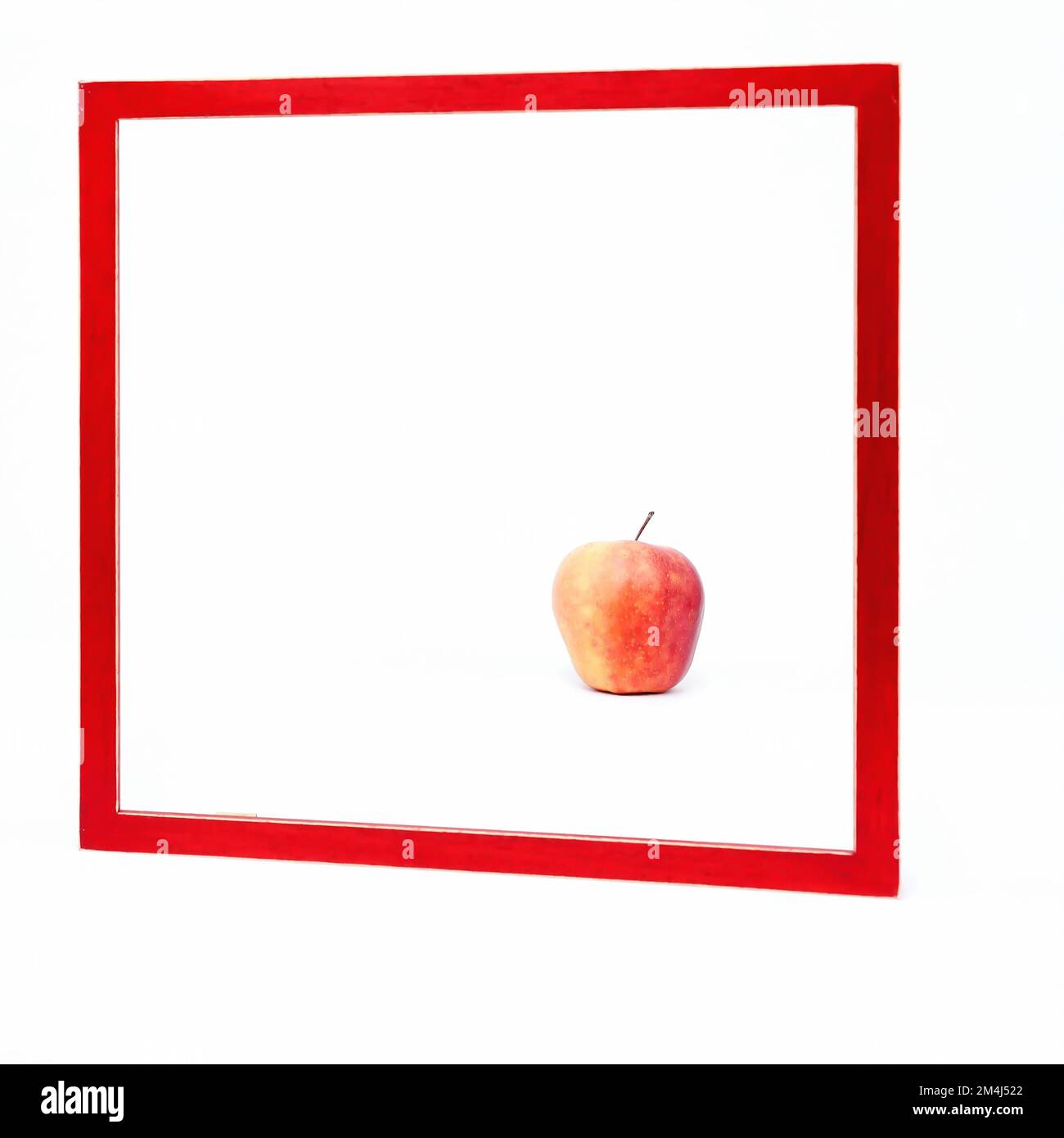 Square red frame set against a white background. An apple stands in the ...