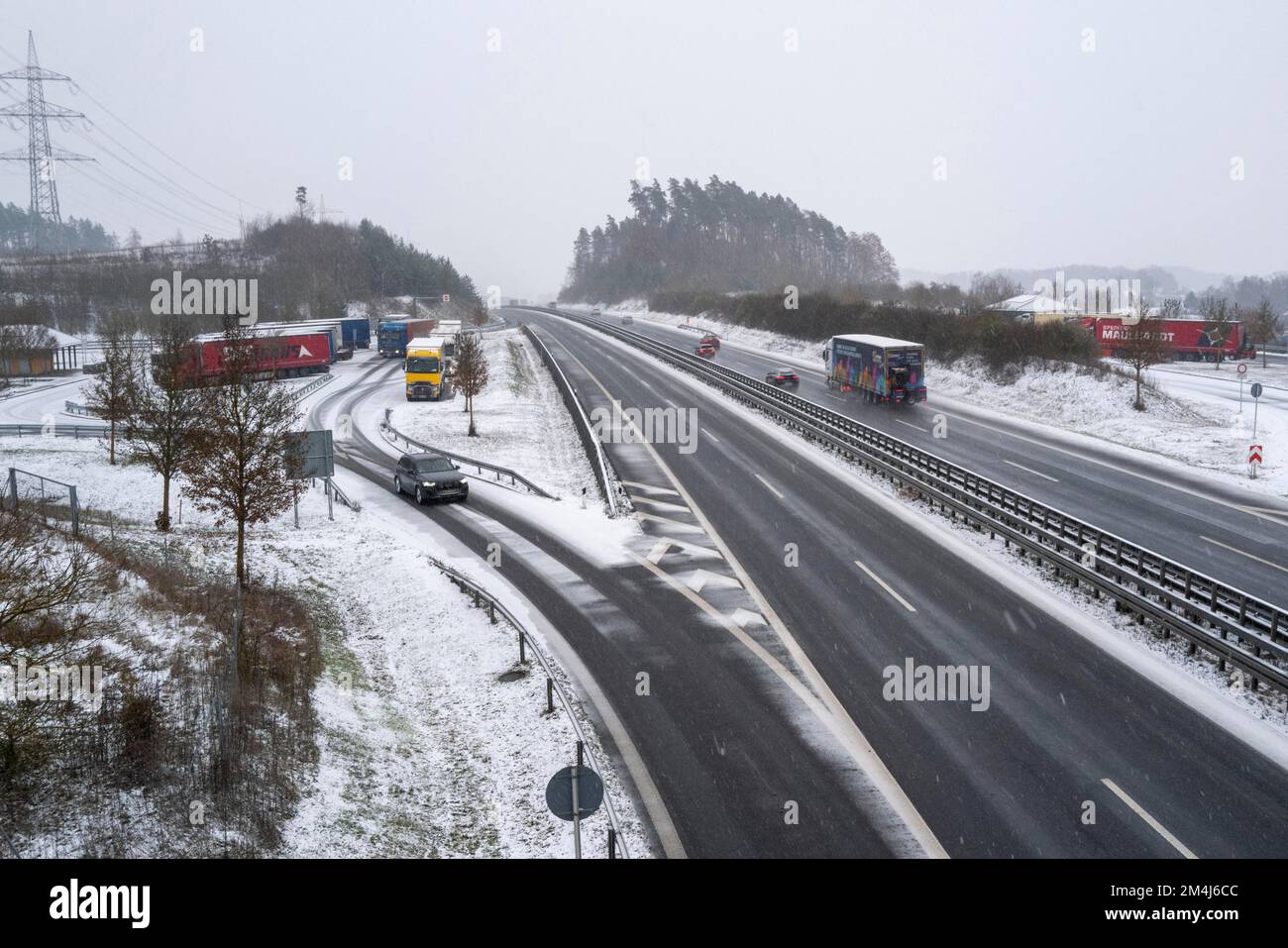 Cars and lorries travelling on a motorway in Bavaria in snowy winter ...