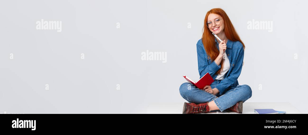 Charismatic, friendly cute redhead girl dreaming, taking notes or ...