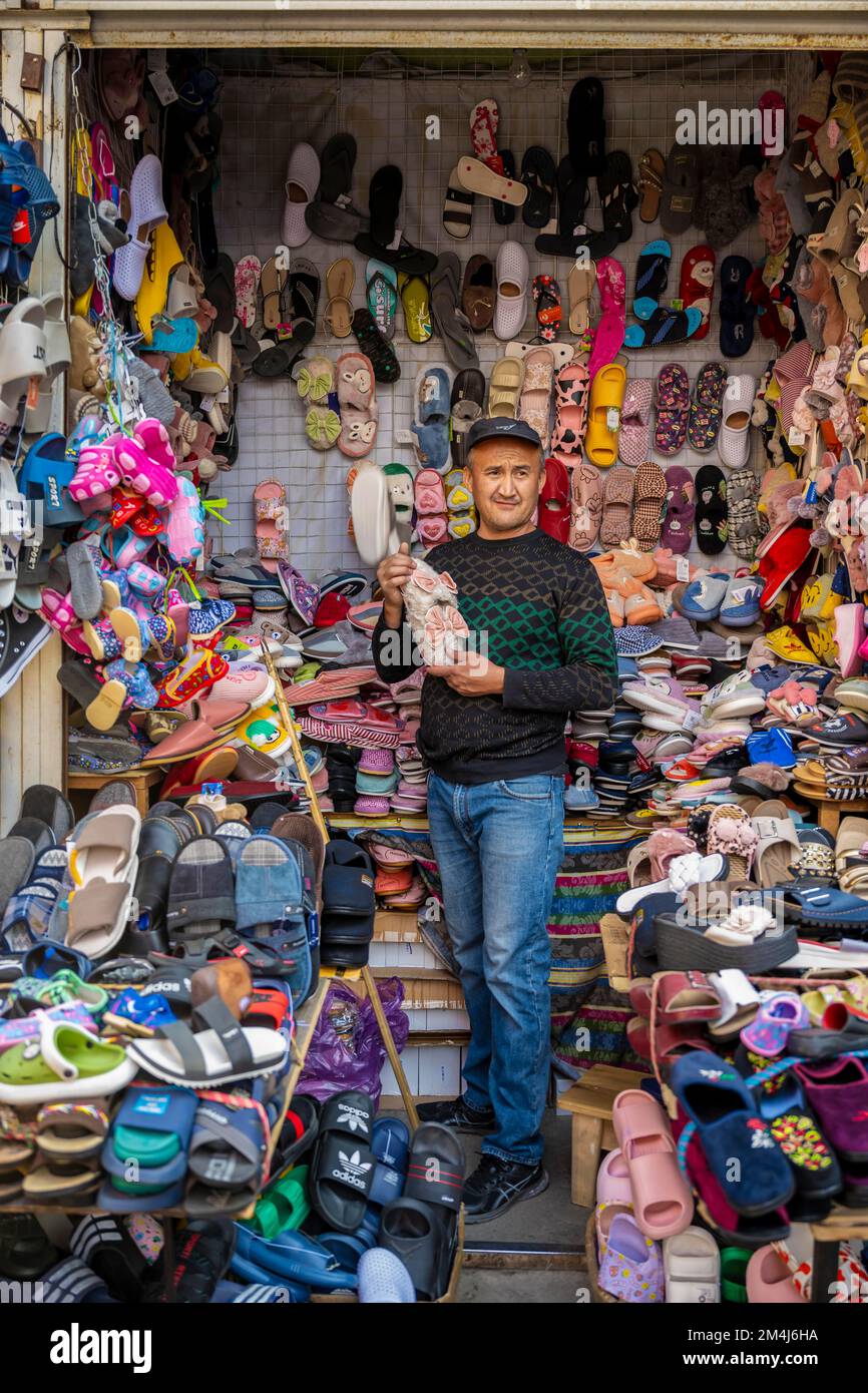 Vendor of shoes in his stall, very many shoes, Osh Bazaar, Kyrgyzstan ...