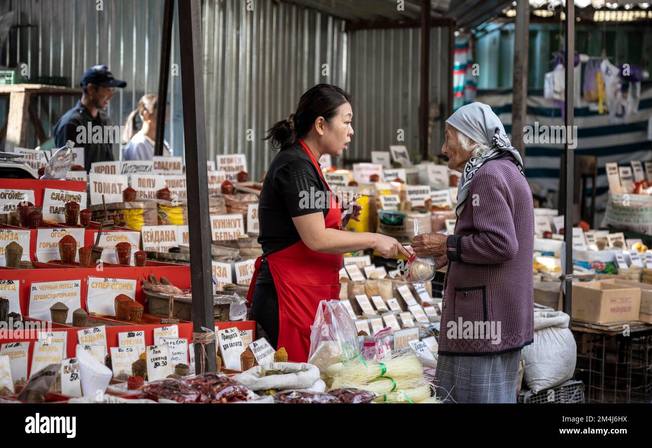 Old woman bargaining with a vendor, Osh Bazaar, Kyrgyzstan, Central ...