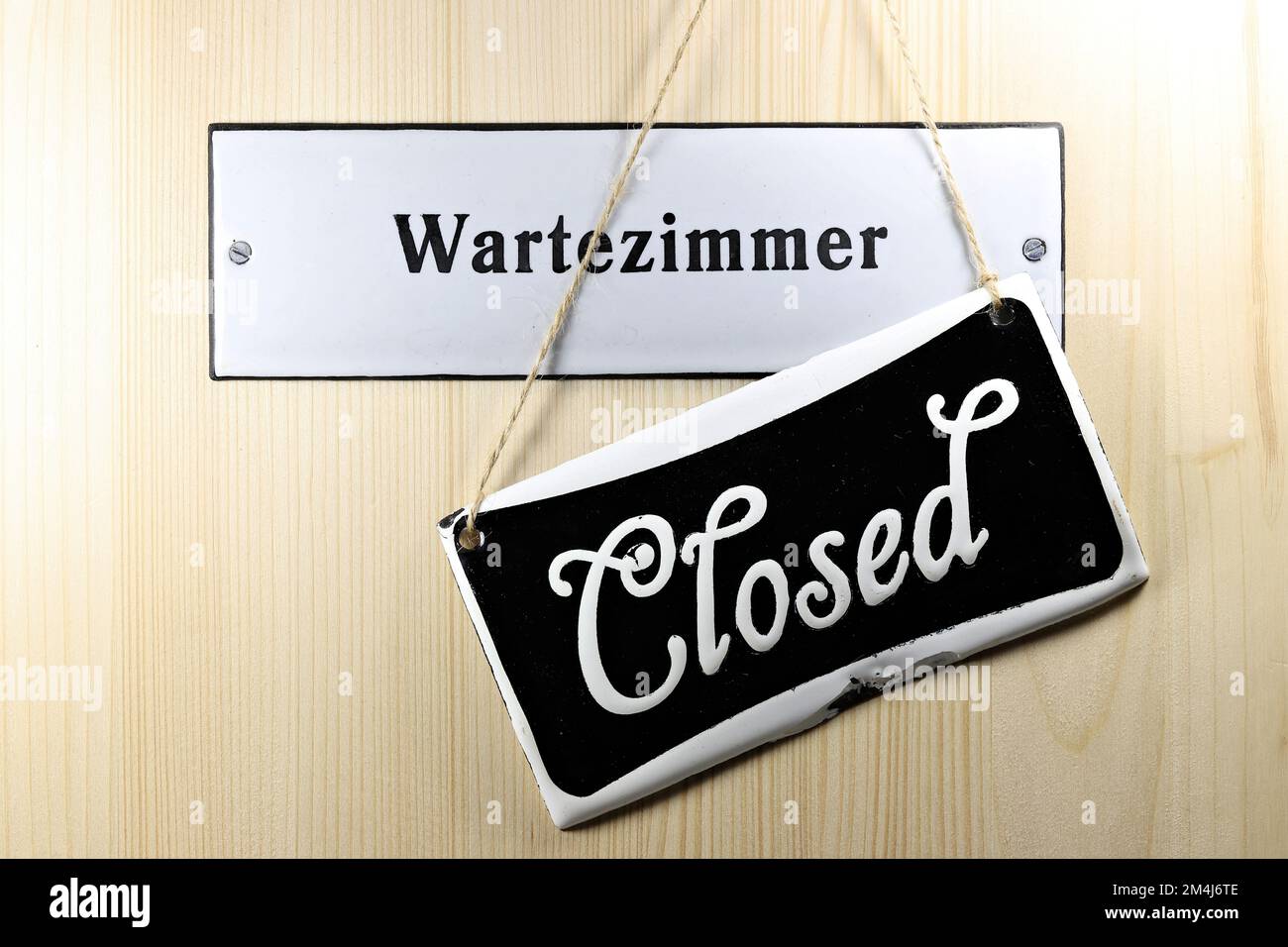 enamel sign on the door to the (closed) waiting room of a German doctor ...
