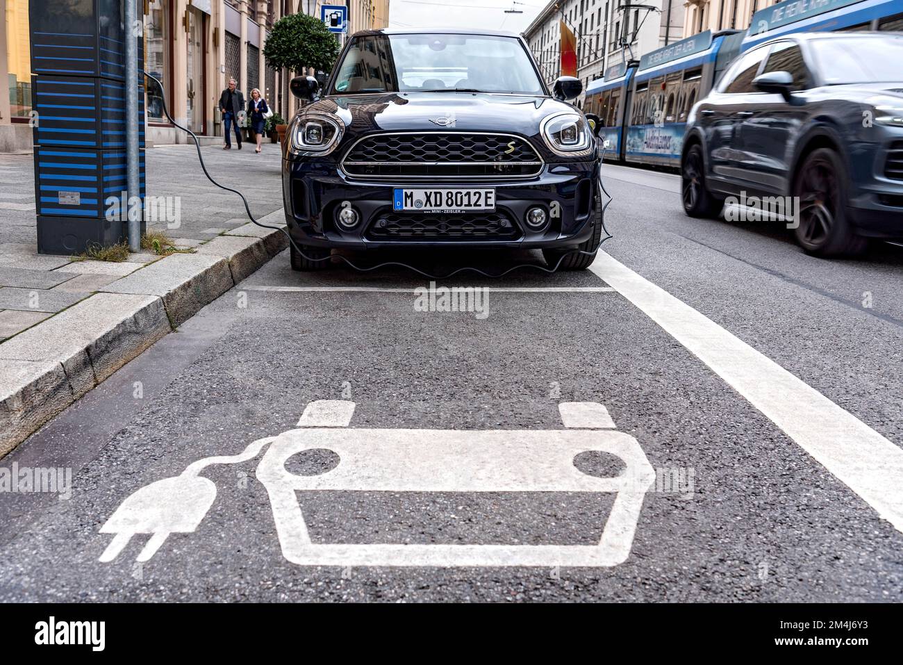 Mini electric car, electric vehicle charging at charging station, logo ...