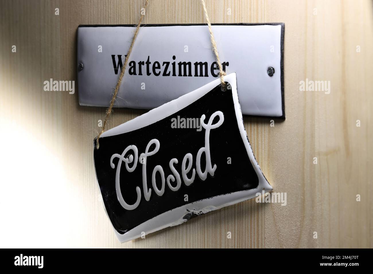 enamel sign on the door to the (closed) waiting room of a German doctor ...