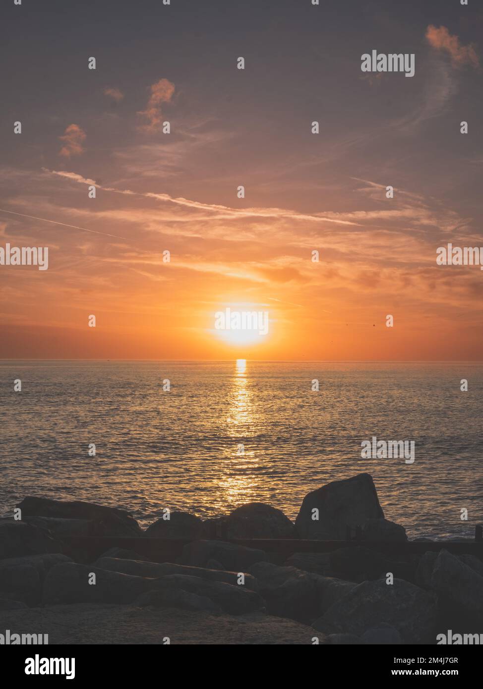 A vertical shot of the beautiful nature scene of the rocky beach with a ...