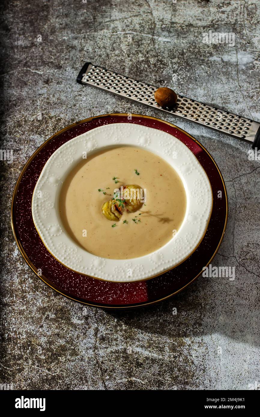 A plate of cream soup of chestnut served at the table Stock Photo - Alamy