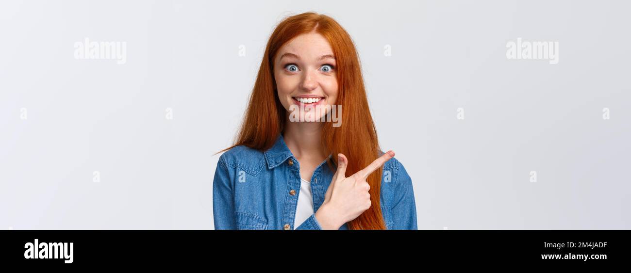 Excited and impressed, curious thrilled smiling redhead girl with long ...