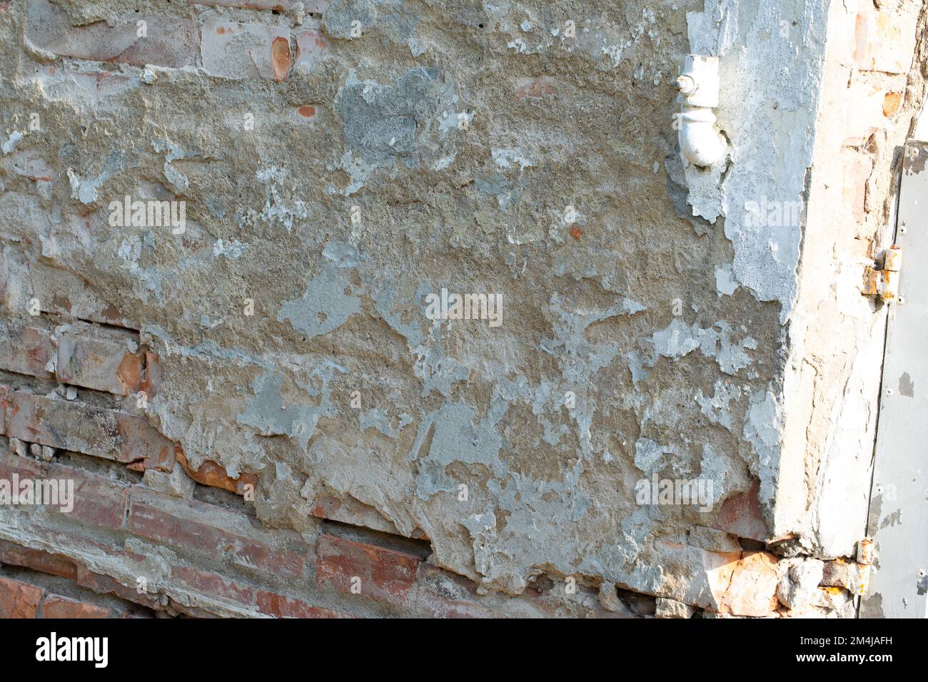 Decaying wall of a house under renovation. Crumbling plaster and broken ...