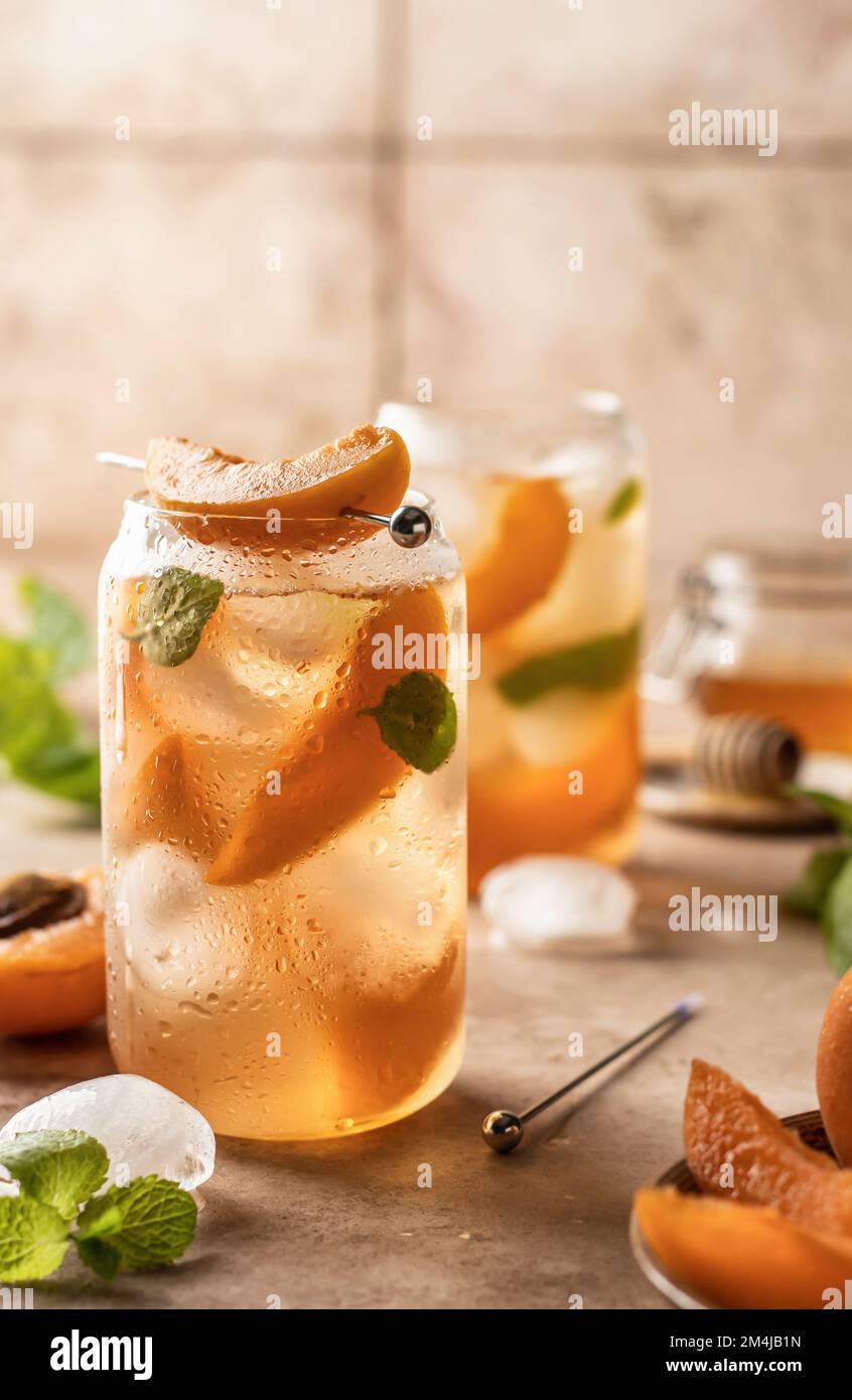 Apricot cocktail, fizz, ice tea with fresh mint and garnish. Pink beige ...