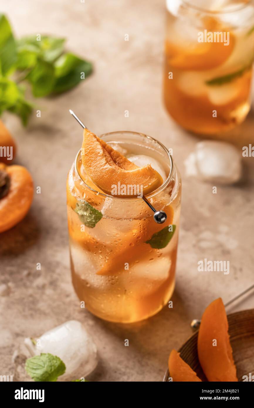 Apricot cocktail, fizz, ice tea with fresh mint and garnish. Beige ...