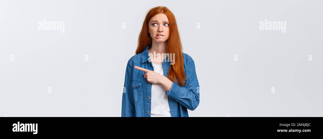 Awkward and nervous cute timid redhead teenage girl having fear or ...