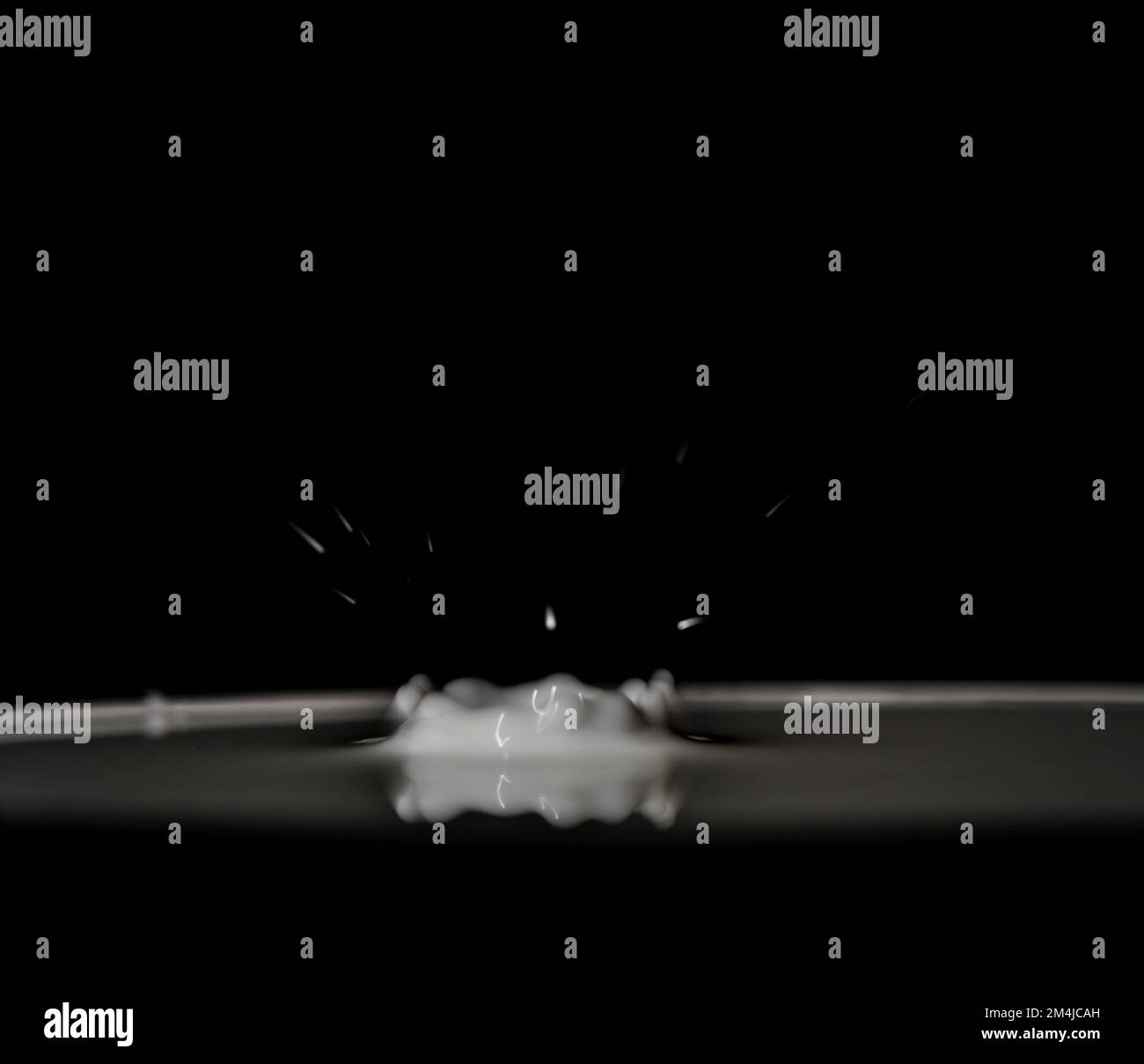 Drop of milk with big waves on surface with dark black background Stock ...