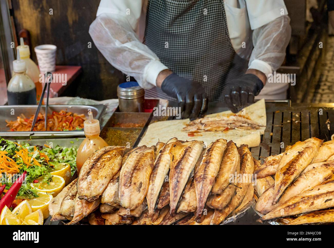 A man preparing a tasty burrito with fish at the street market Stock ...