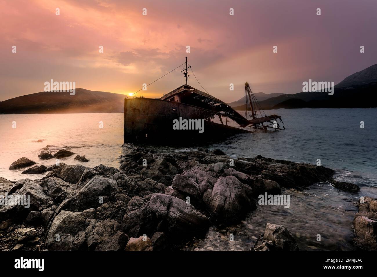 The silhouette of an old half-drowned ship at the coast of a sea at ...