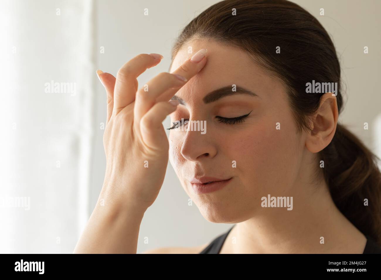 Meditation and relaxation. Woman with relaxed face massaging a pressure ...
