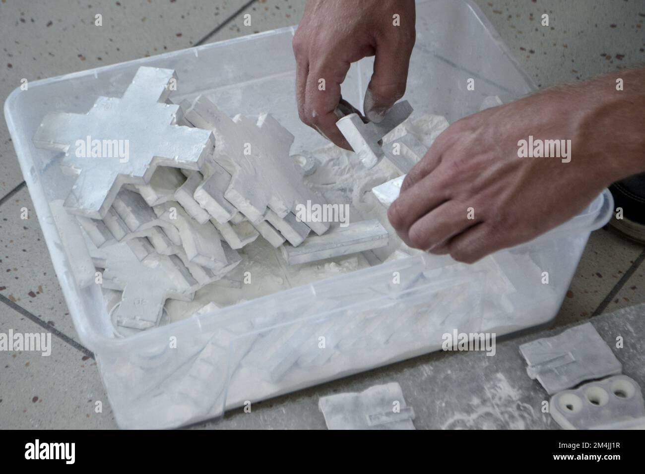 Male worker sorts through models in hands, lying in box and covered ...