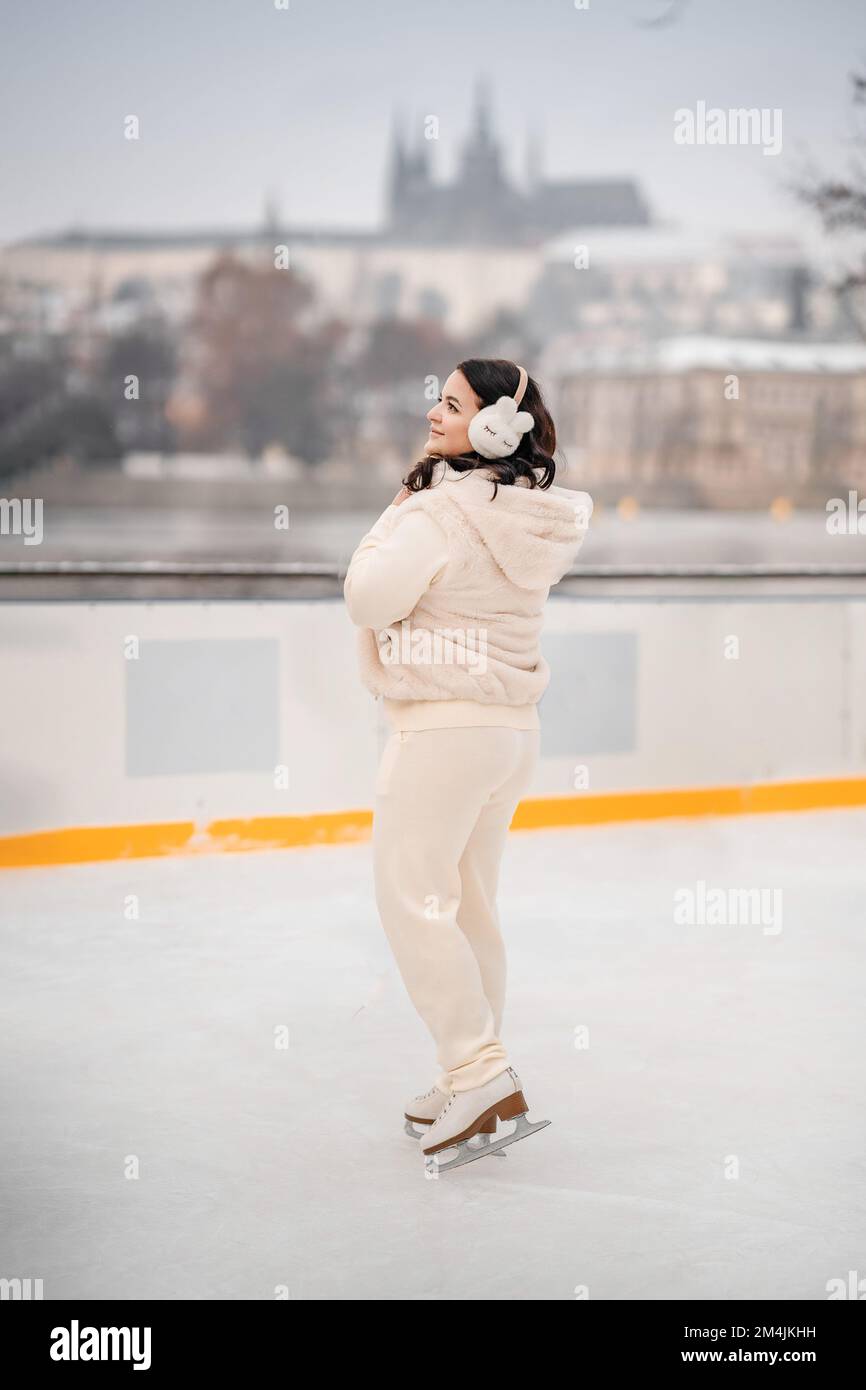 Beautiful girl having fun while skating at ice rink on Prague castle ...