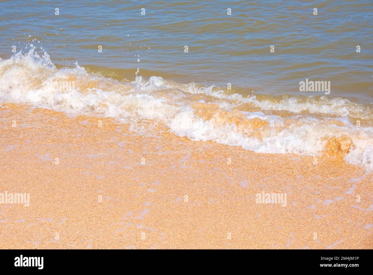 The coast of the Sea of Azov. Sea waves roll on the sandy shore ...