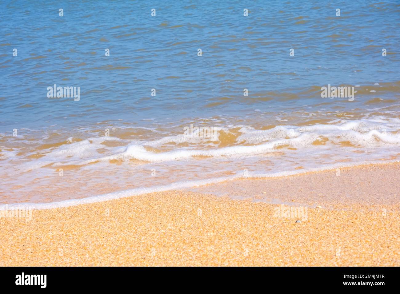 The coast of the Sea of Azov. Sea waves roll on the sandy shore ...