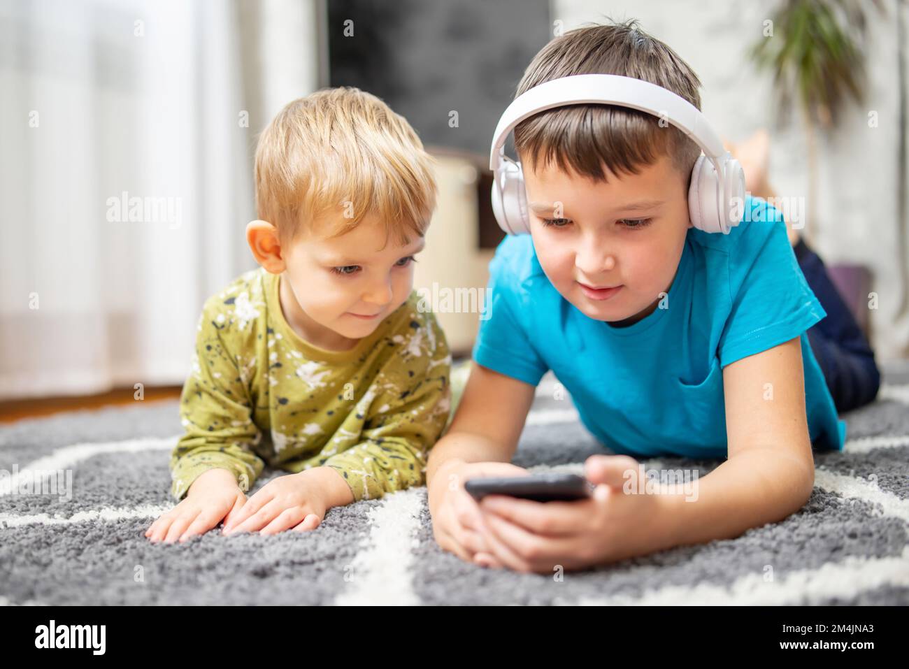 Two children watching smart phone, happy kids using smartphones ...