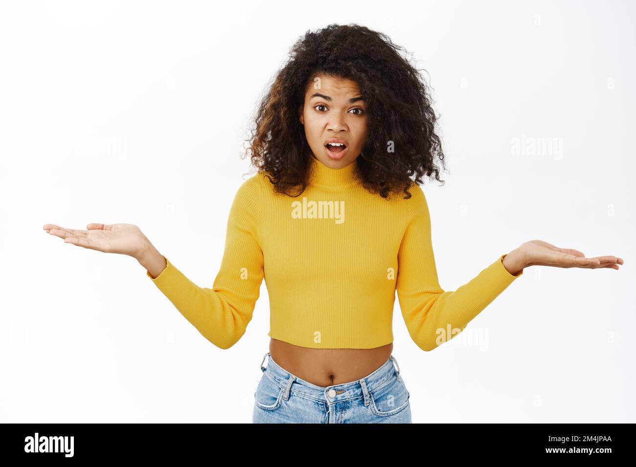 Confused and frustrated black girl, shrugging shoulders, spread hands ...