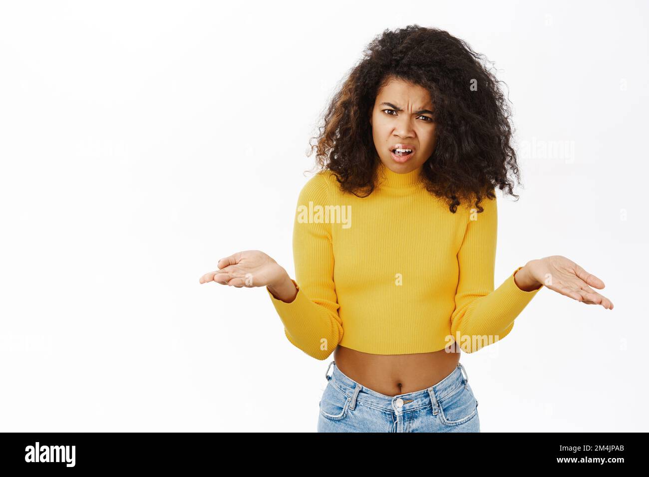 Confused and frustrated black girl, shrugging shoulders, spread hands ...