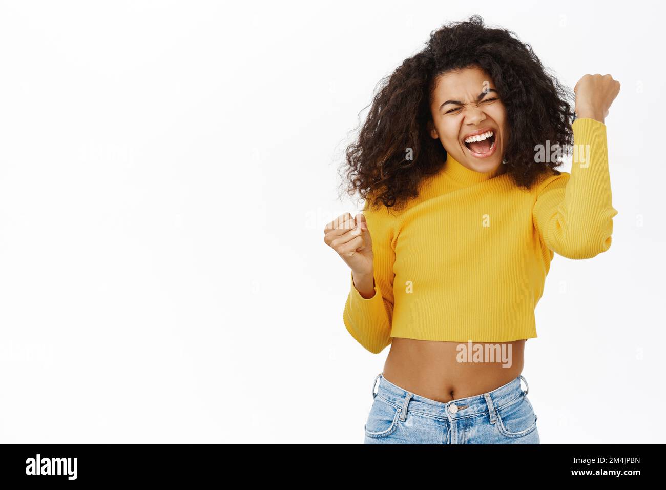 Enthusiastic happy african girl dancing and celebrating, winning and ...